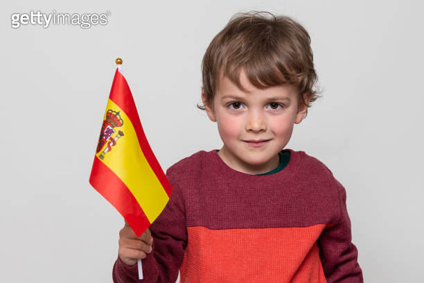 Smiling Spanish Child boy looking at the camera waving the flag of ...