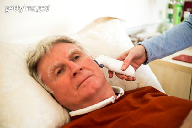 Sick senior man in bed with fever having temperature taken 이미지 ...