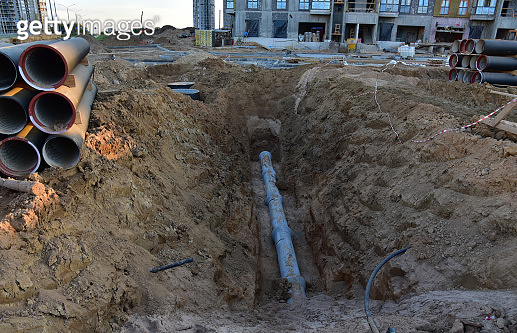 Laying of underground storm sewer pipes in ditch. Installation of water ...