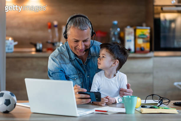 Happy business father and his son using cell phone while working at ...
