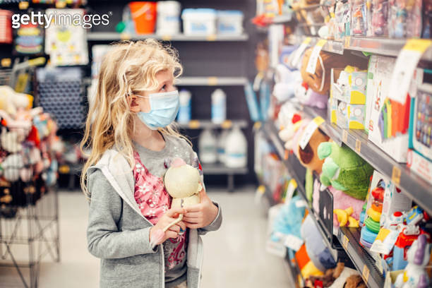 A new normal. Caucasian blonde girl in sanitary face mask shopping at ...
