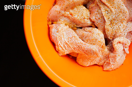 Cut pieces of uncooked chicken, seasoned with turmeric paste, inside ...