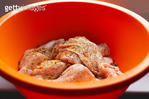 Cut pieces of uncooked chicken, seasoned with turmeric paste, inside ...