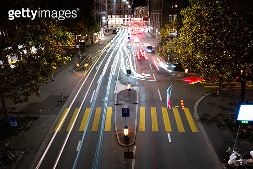 Car light trails long exposure traffic in busy street junction at night ...