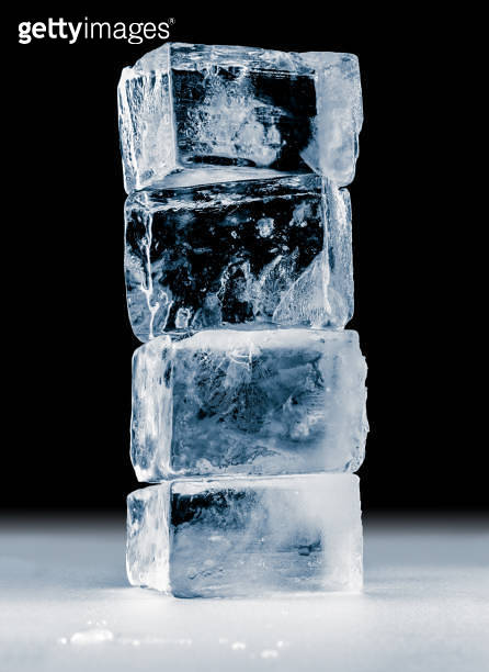 Stacked textured transparent frosted crystal clear ice blocks on black ...