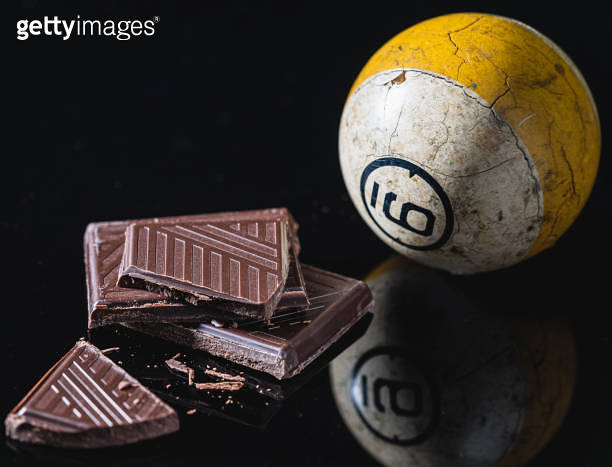Dark chocolate bar into pieces. Billiard ball in the background. 이미지 ...