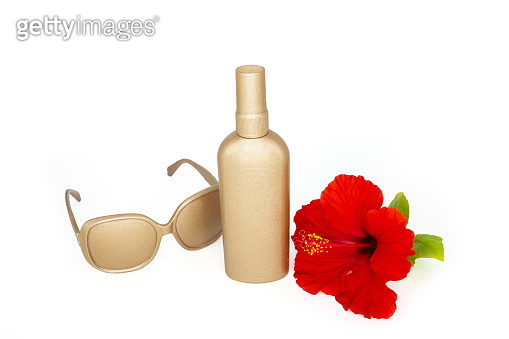 Sunscreen spray lotion golden bottle, tropical flower and sun glasses ...