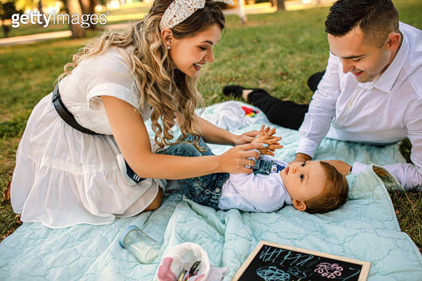 Happy family with one child playing in the park (1277139142) - 게티이미지뱅크