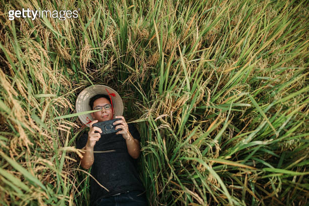 Asian chinese handsome farmer take a break and using mobile phone while ...