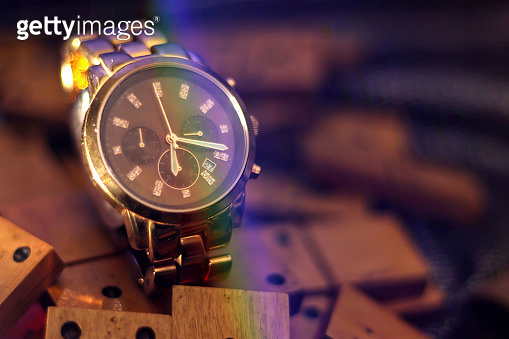 Luxurious gold watch on top of domino pieces and dark background with a ...