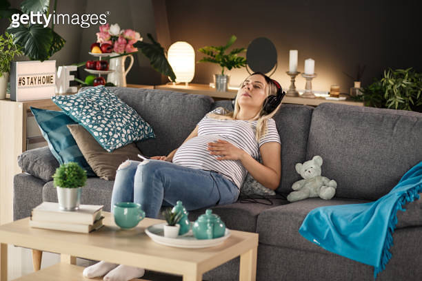 Pregnant woman giving herself a moment of enjoyment with her favorite ...