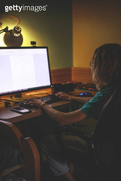 Sitting by the computer to complete activities for homeschooling during ...