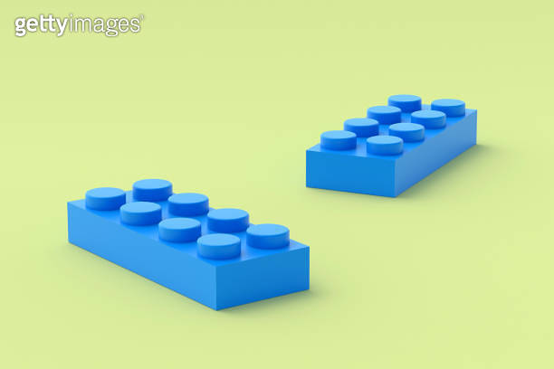 Blue plastic toy blocks on yellow background. Rectangular shape ...