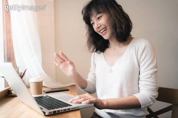 Young Asian woman working and video conferencing with laptop computer ...