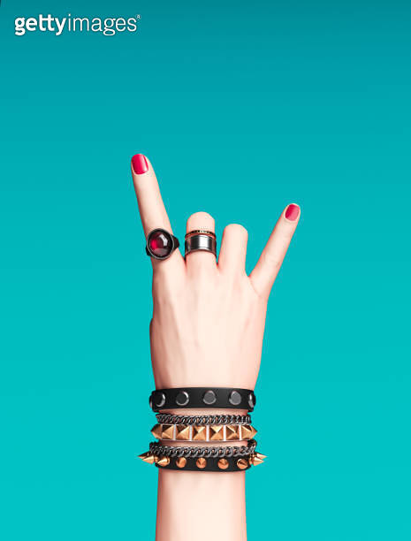 Rock hand sign, female hand punk rock gesture with gold wrist bracelets ...