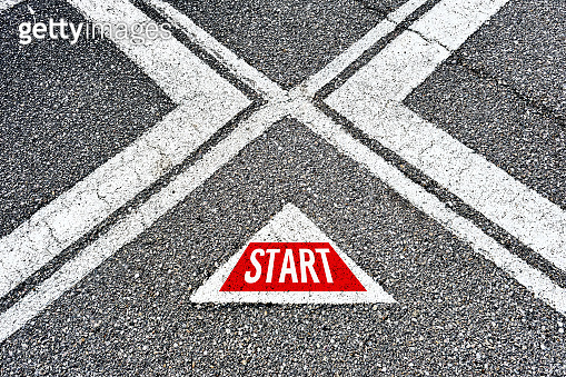 The word start written on asphalt road with directional arrow. Starting ...