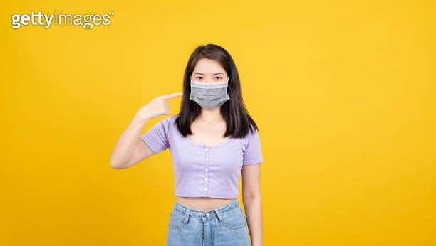 Asian woman wearing mask pointing correct for protection against germs ...
