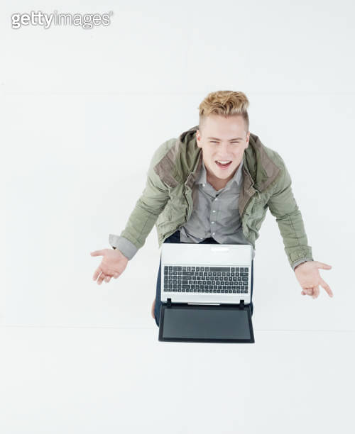 Caucasian male sitting in front of white background wearing pants and ...