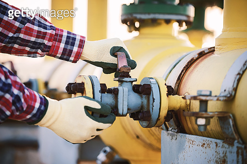 Worker checking valves on the fuel supply systems, close up photo ...