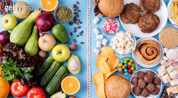 Fruit and vegetables vs sweets and fast food top view flat lay on blue ...