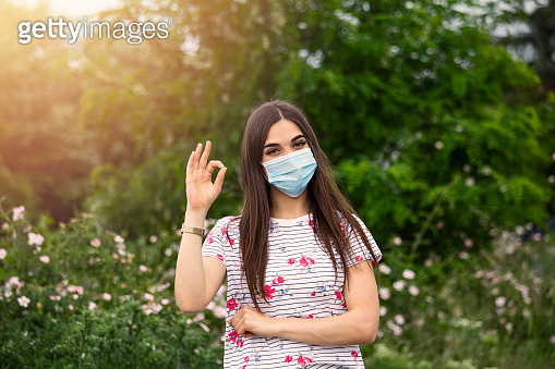 Young woman wearing medical face mask outdoors. Woman Wearing ...