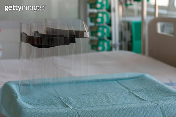 Three plastic protective shields on table in ICU in hospital, personal ...