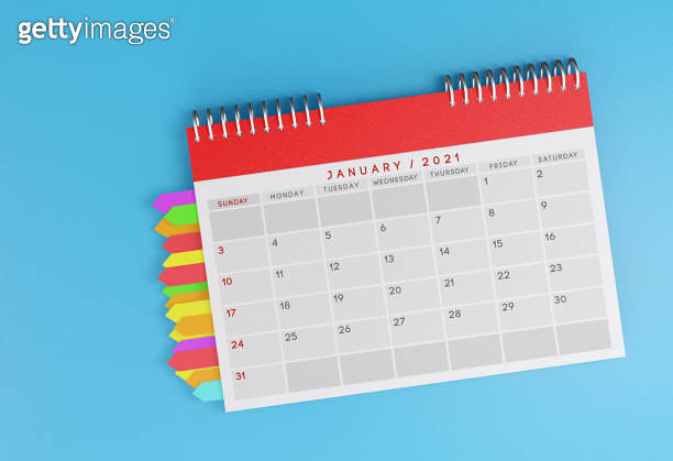 January 2021 desk calendar on a blue background. Sticky notes between ...