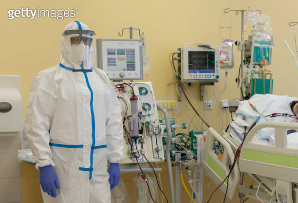 Male nurse with protective coverall clothing in intensive care unit in ...