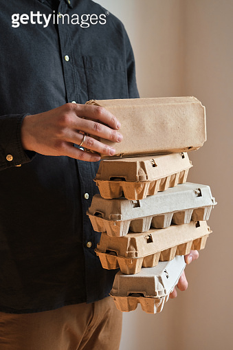 Cardboard boxes with chicken eggs. A man holds boxes with uncooked eggs ...