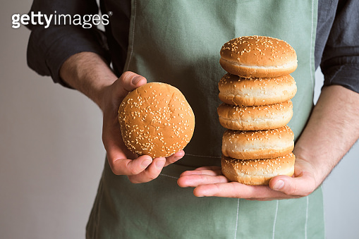 Burger buns in the hands of a man. Baking buns. Cooking hamburger ...