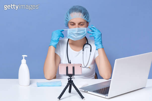 Indoor shot of doctor wearing protective mask and clothes, holding ...