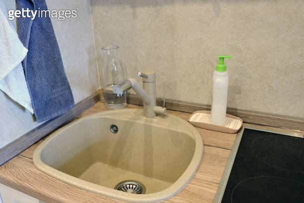 Empty kitchen sink with faucet and clean towels on the wall (1217348157 ...