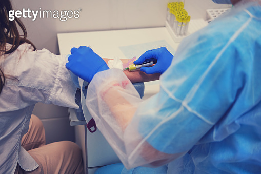 Doctor giving an injection to a woman for a test for antibodies to ...