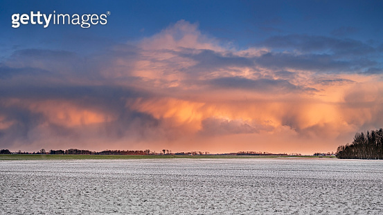 Pink snow storm cloud formation during sunset , large snow covered ...