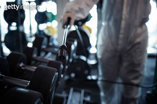 Close up view of gym disinfection and healthcare. Man in white ...