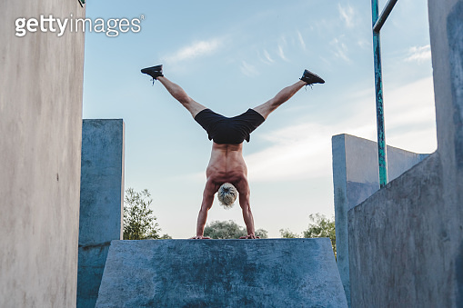 Handstand yoga pose by athlete man on the sport ground outdoors ...