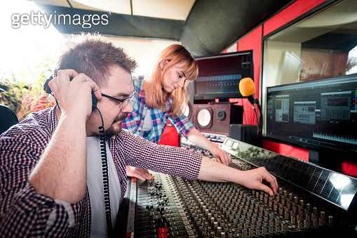 Music engineer and musician working together in recording studio using ...