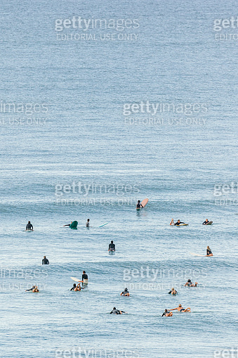 A large group of surfers are at Tea Tree Bay in Noosa National Park in ...