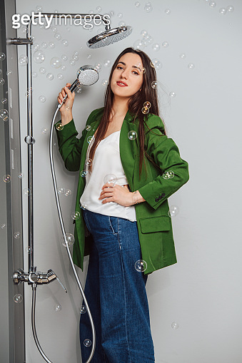 Beautiful young woman standing with a sprinkler in a shower cabin fully clothed 이미지 (1264836423 ...