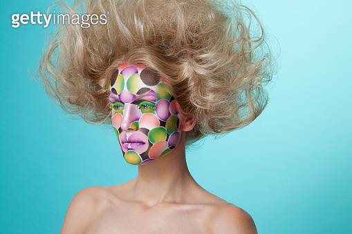 Profile portrait of a female model with colored face painted and ...