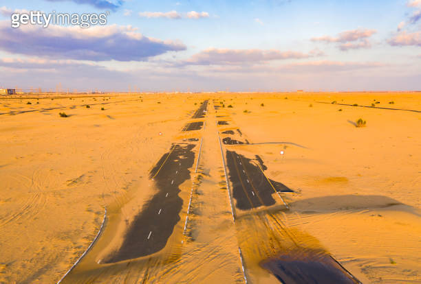 Aerial view of half desert road or street with sand dune in Dubai City ...