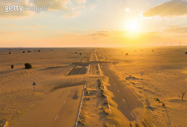 Aerial view of half desert road or street with sand dune in Dubai City ...