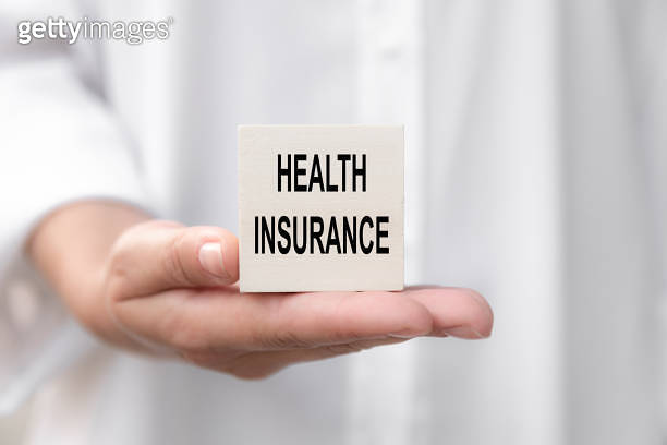Text Health Insurance written on cube in hahd of female doctor, medical ...