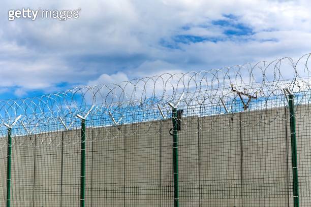 Barbed wire and concrete wall. Military base. State border. Prison wall ...