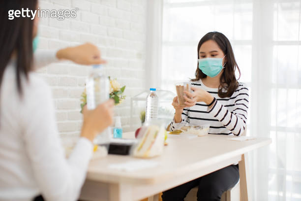 Young Asian woman sitting separated in restaurant or home eating food ...