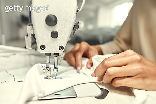 Stitching Up. Close up of seamstress hands. She is sitting and sewing ...