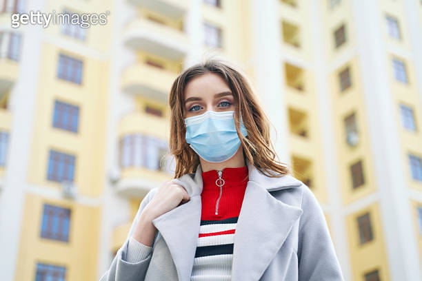 Young woman with beautiful blue eyes wearing protection face mask ...
