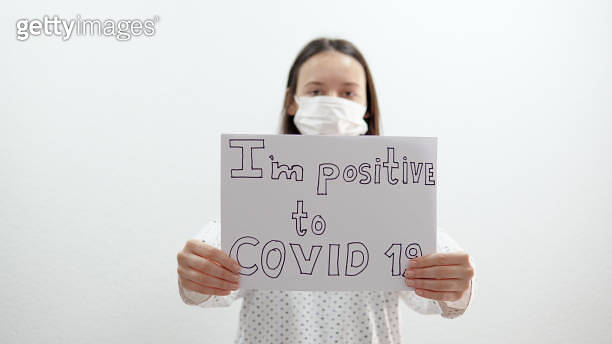 Patient in hospital quarantine isolation holding paper with text shows ...