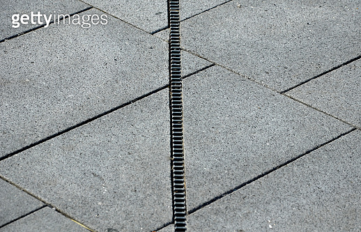 large-format paving made of gray granite. the water is drained in the ...