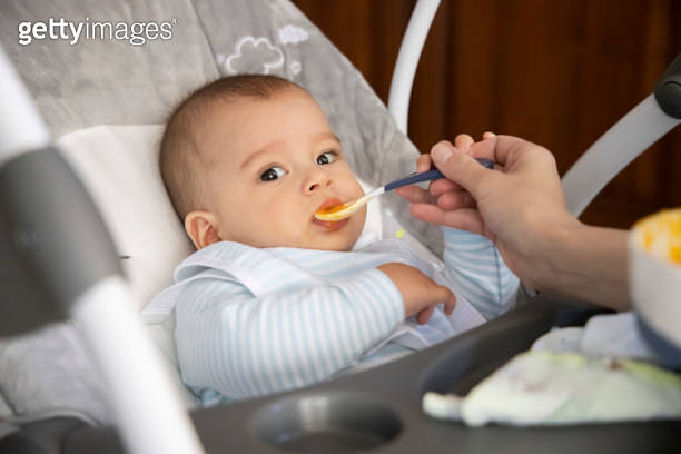 First feeding a baby. Feeding pumpkin puree. Happy baby. 이미지 ...